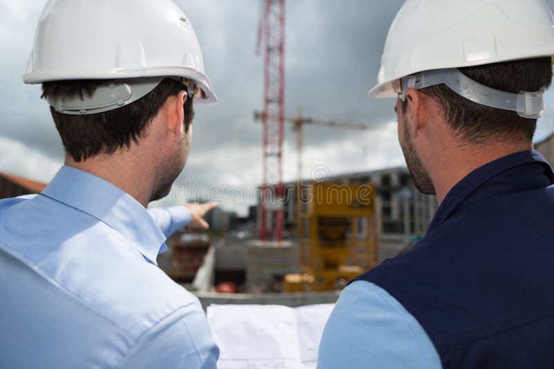 Engineer and Worker Checking Plan on Construction Site Stock Photo ...