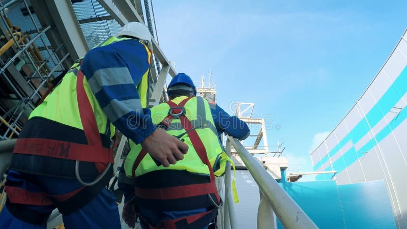 Engineer and Worker Climbing the Tower of a Large Oil Refinery Stock ...