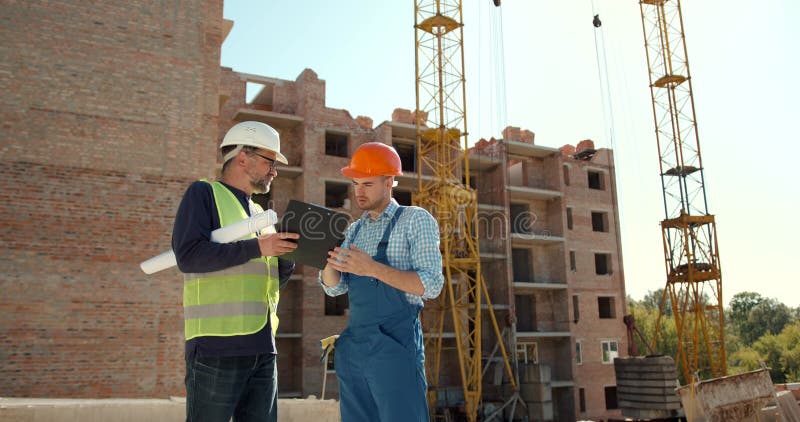 Engineer and Worker Looking at Notepad at Construction Stock Video ...