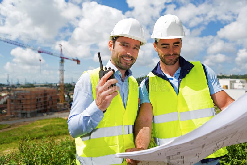 Engineer and Worker Watching Blueprint on Construction Site Stock Photo ...
