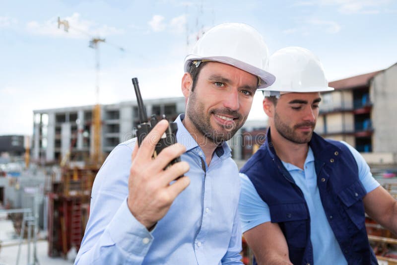 Engineer and Worker Watching Blueprint on Construction Site Stock Photo ...