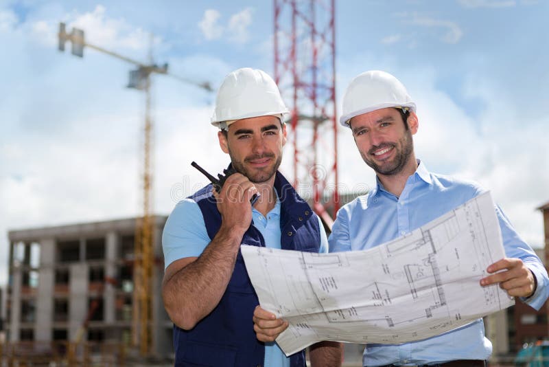 Engineer and Worker Watching Blueprint on Construction Site Stock Photo ...