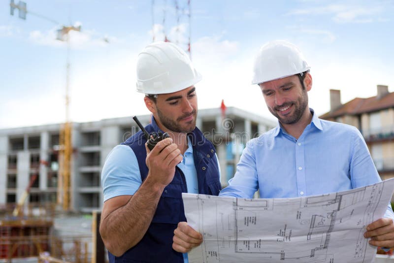 Engineer and Worker Watching Blueprint on Construction Site Stock Photo ...