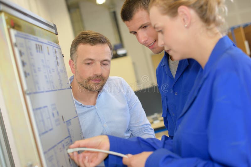Engineer Working with Apprentices on Factory Floor Stock Photo - Image ...