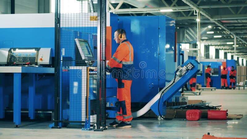 Engineer Working on an Assembly Line at a Modern Industrial Factory ...