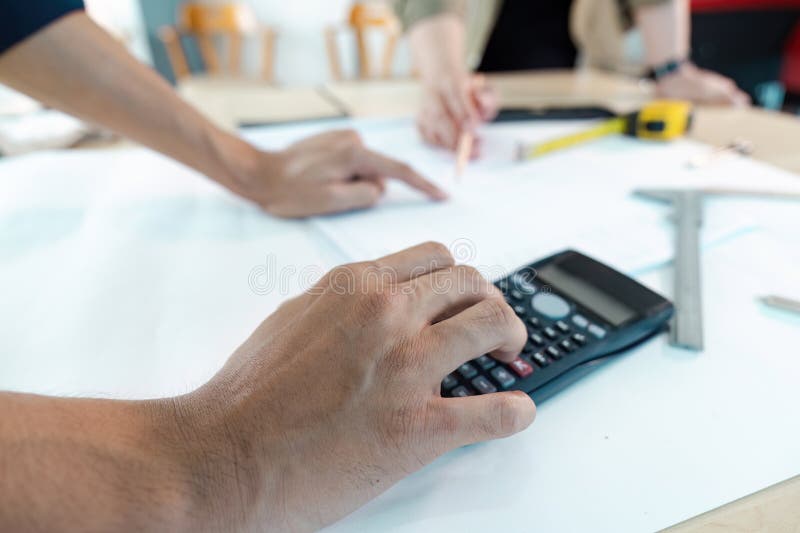 Engineer Working on Blueprint with Calculator and Tools in Office ...