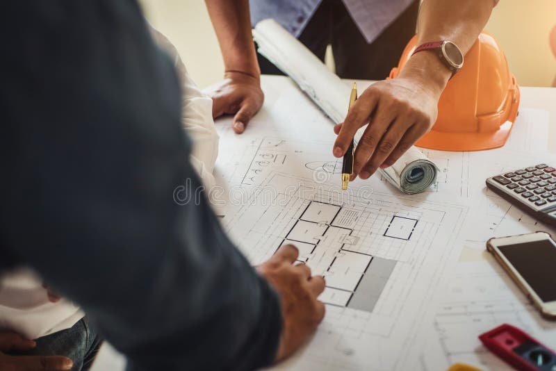 Engineer Working at a Blueprint of House in Office for Discussing Real ...