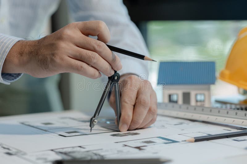 An Engineer is Working in His Office and Using Various Equipment To ...