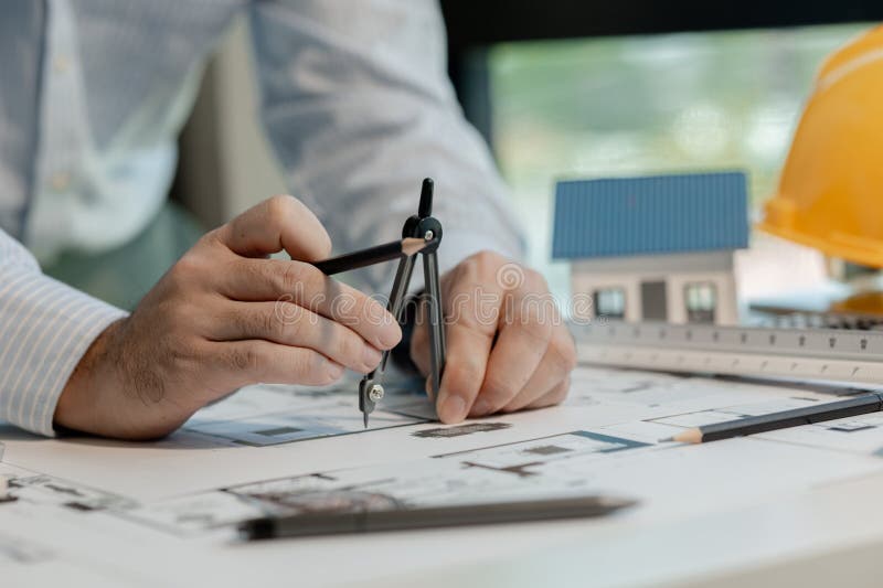 An Engineer is Working in His Office and Using Various Equipment To ...