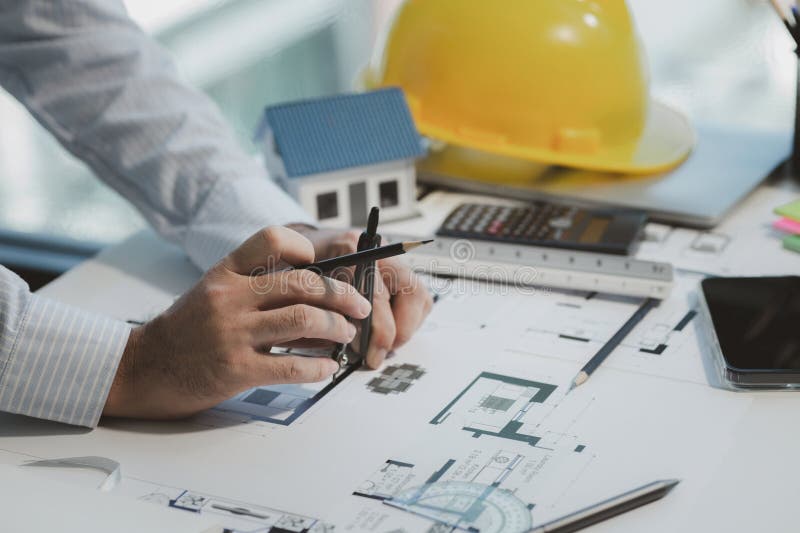 An Engineer is Working in His Office and Using Various Equipment To ...