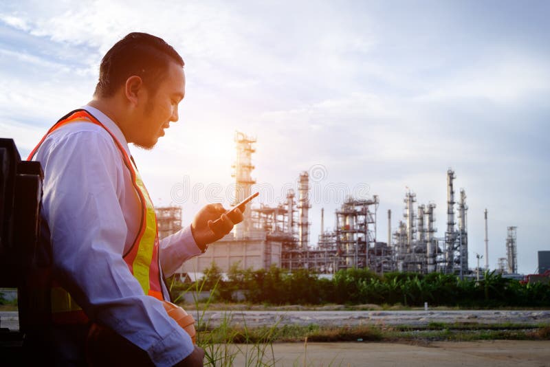 The Engineer is Working with Smart Phone with Large Industry Background ...