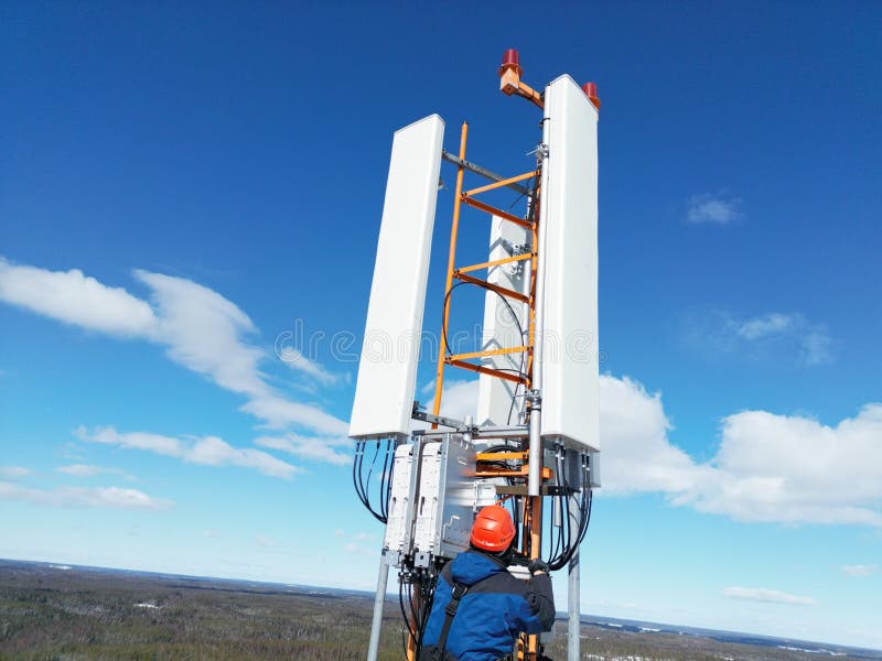Engineer Working on a Telecommunications Tower Against the Background ...