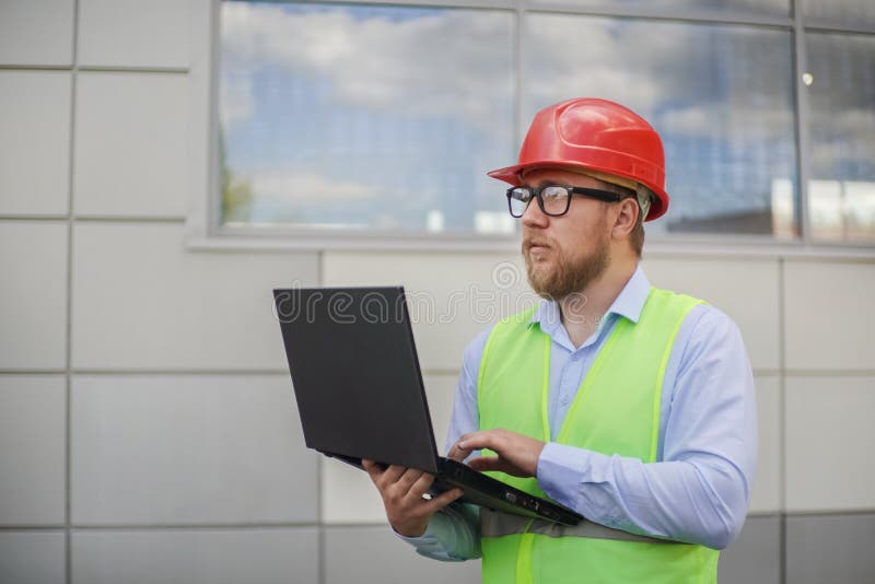 Engineer works on laptop stock photo. Image of helmet - 254497906