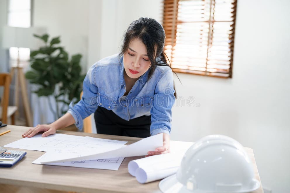 Engineering Construction Concept, Female Engineer is Checking Blueprint of Condominium in Office ...