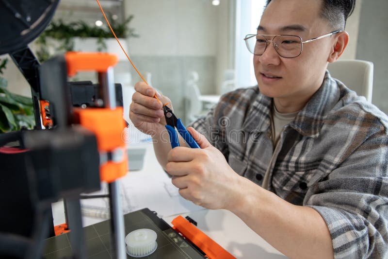 Men Working with 3D Printer and Blueprint for Designing Mechanical Parts in High Tech Workshop ...