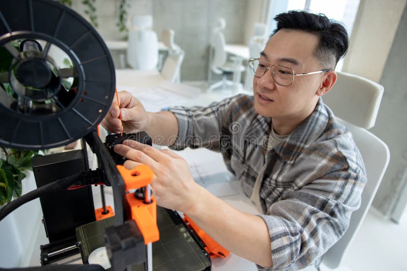 Men Working with 3D Printer and Blueprint for Designing Mechanical Parts in High Tech Workshop ...
