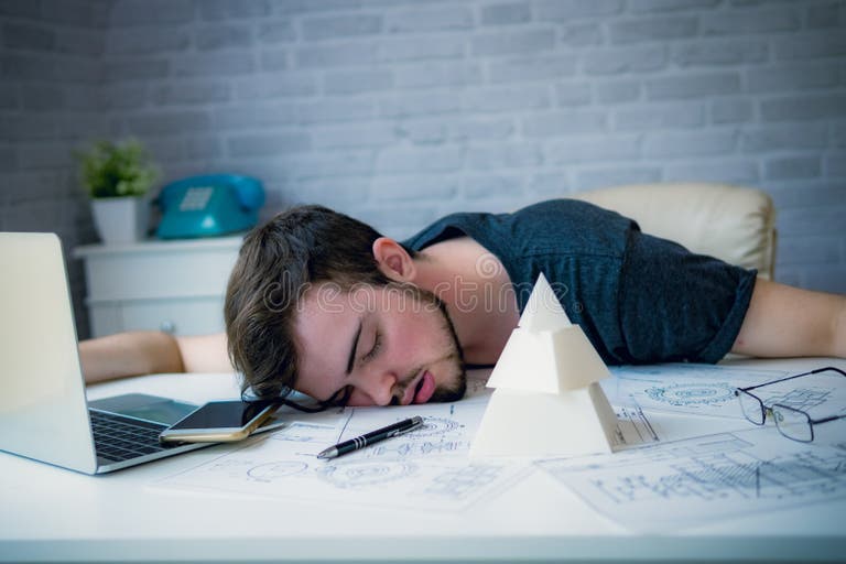 Engineering Man Working Overwork and Sleep on the Desk with Blue Stock ...
