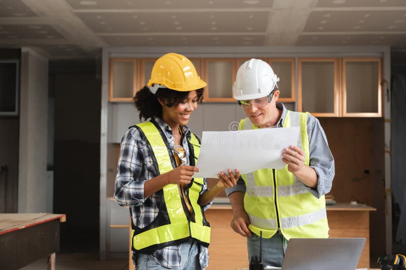 Engineers Discussing Construction Plans, Holding Blueprints, Wearing ...
