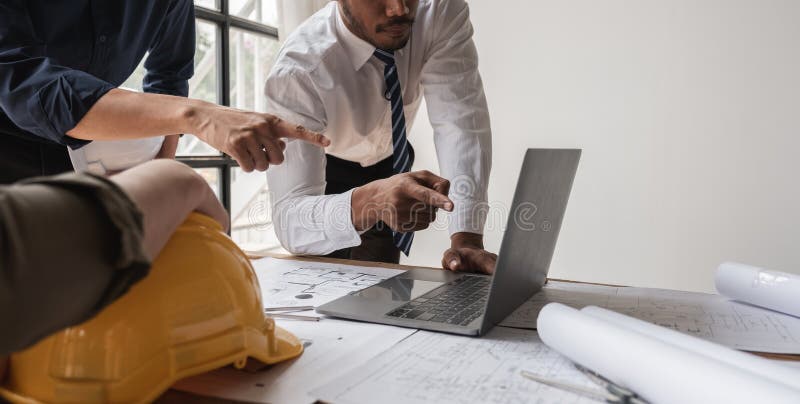 Engineering Team Collaborating on Work Plans Around a Table with ...
