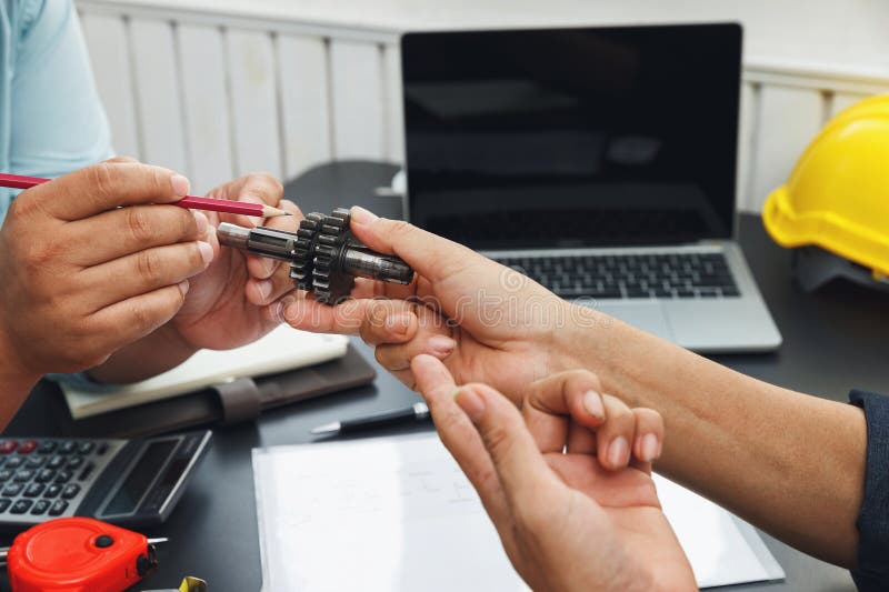 The Engineering Team Point To the Gear and Discussing on Their Project ...