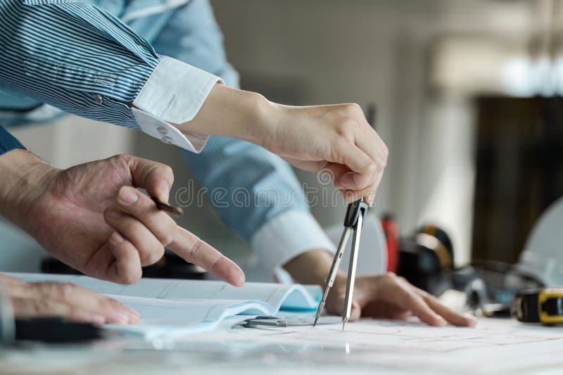 Engineer and Architect Collaborate on Blueprint Design in Modern Office ...