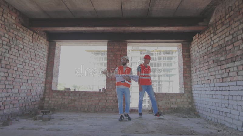 Engineers with a Blueprint Inside a New House. Builders Inside a New ...