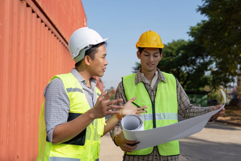 Engineers Collaborating on Logistics Strategies, Examining Blueprints ...