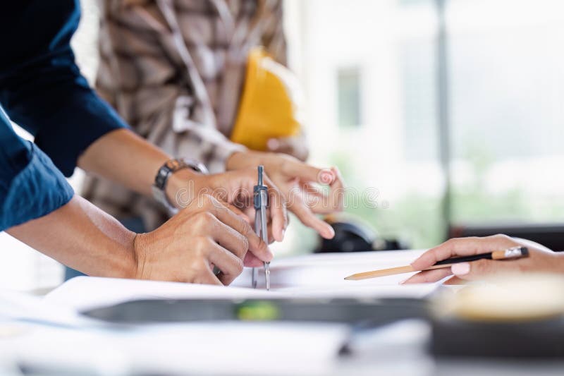 Engineers Collaborating on Project Plans with Technical Drawings and ...