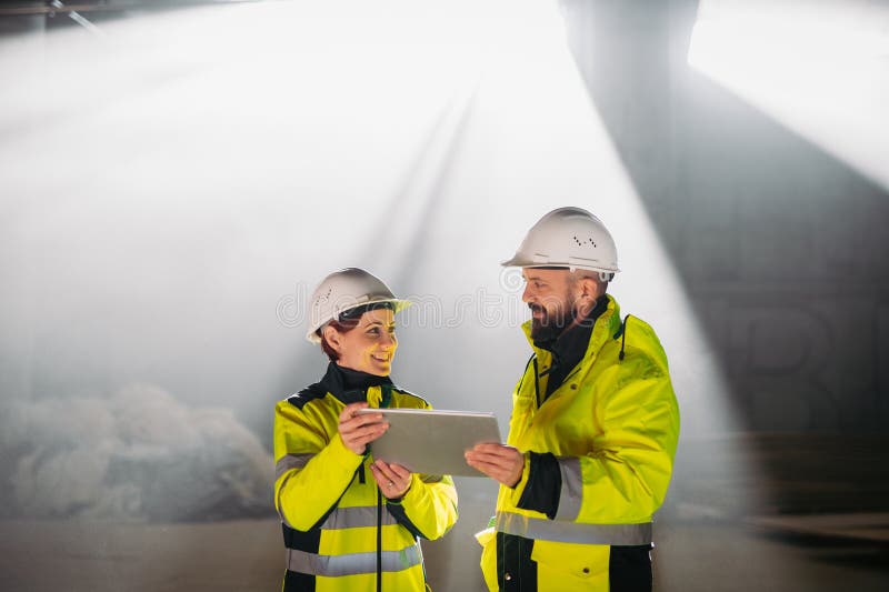 Engineers Discussing Construction Plans Using a Tablet on Site. Stock ...