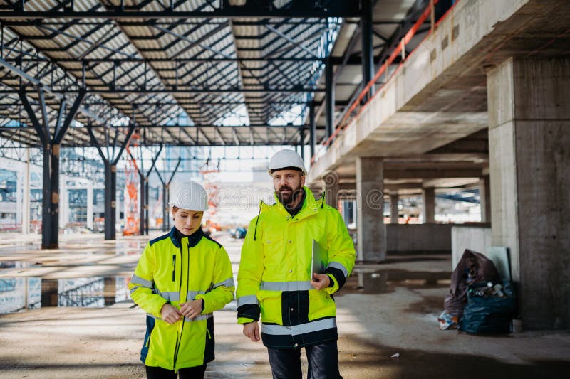 Engineers Discussing Construction Plans Using a Tablet on Site. Stock ...