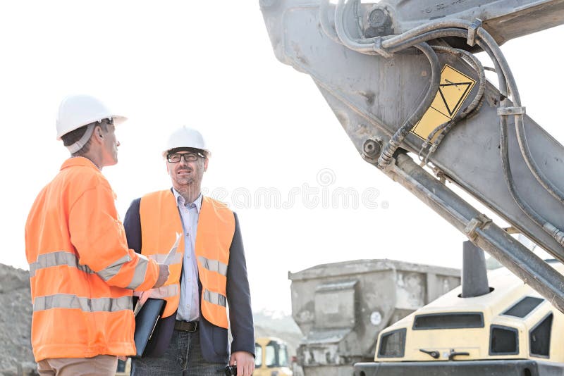 Engineers Discussing at Construction Site Against Clear Sky Stock Image ...