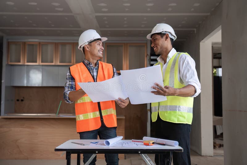 Engineers Discussing and Planning Construction Project while Holding ...