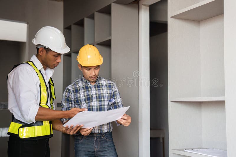 Engineers Discussing Construction Plans, Holding Blueprints, Wearing ...