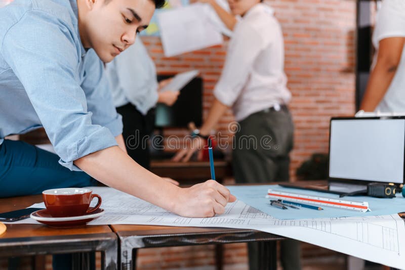 Engineers Holding a Pen Pointing To a Building and Drawing Outlay ...