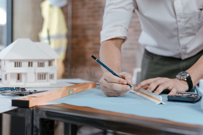 Engineers Holding a Pen Pointing To a Building and Drawing Outlay ...