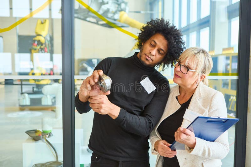 Engineers Inspecting Robotic Gripper Part in Industrial Workspace for Automation Process Stock ...