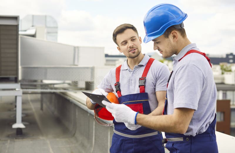 Engineers Planning Construction Site with Blueprints on Roof Stock ...