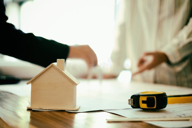 Engineers Pointing To Building on Blueprint and Using Laptop To Drawing ...