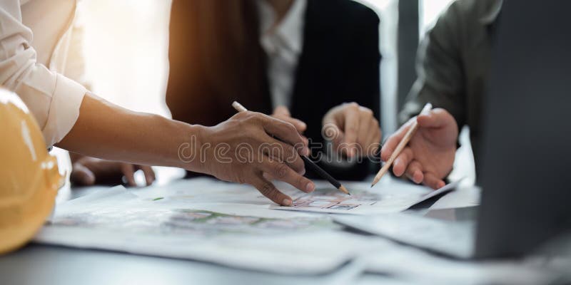 Engineers Pointing To Building on Blueprint and Using Laptop To Drawing ...