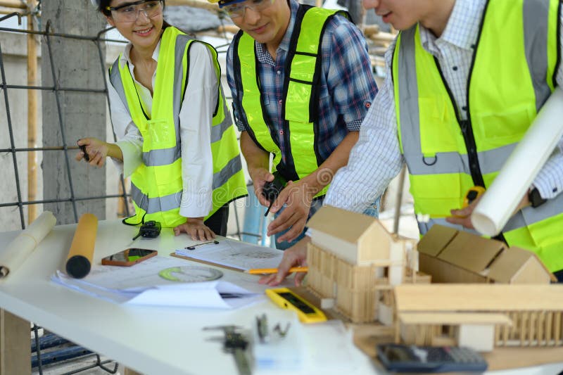 Engineers Team Working at Construction Site with Architectural Models ...