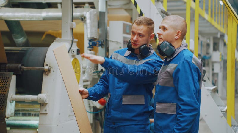 Engineers Technicians on Production Workshop are Setting Up a Cardboard ...