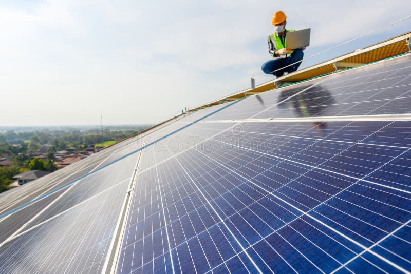 Engineers Use a Laptop Computer To Examine the Solar Panels on the Roof ...