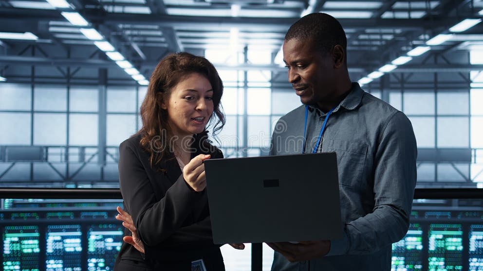 Engineers Using Laptop In Data Center Managing Server Virtualization