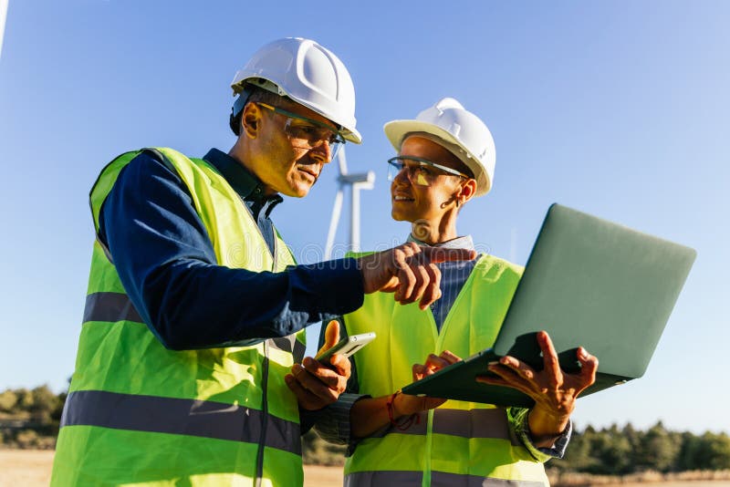 Engineers Using a Laptop while Working Together in the Wind Farm. Stock ...