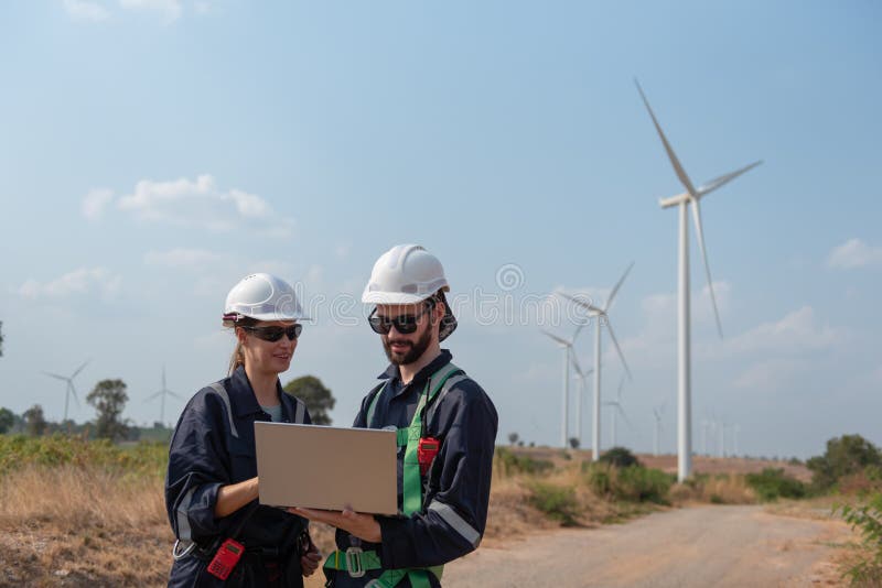 Engineers Working and Using a Computer Laptop on Site in Wind Turbine ...