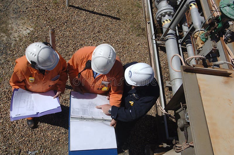 Engineers on Worksite at Refinery Discuss the Plans-above Shot. Stock ...