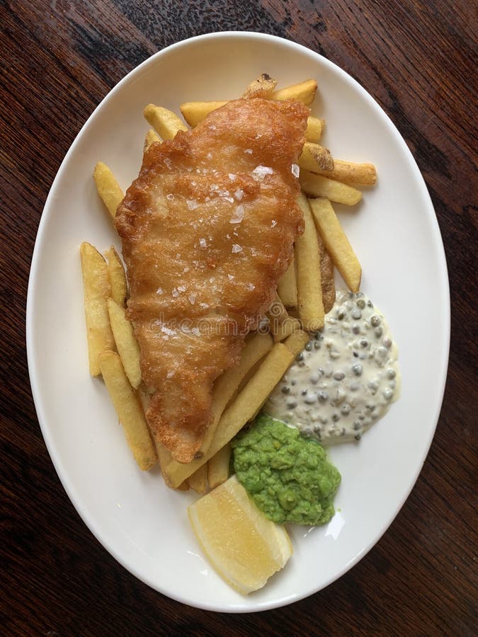 Traditional English Dish of Fish and Chips with a Side Order of Mushy ...