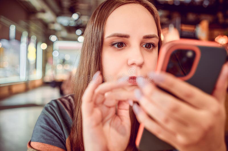 Engrossed Coffee Enthusiast Captivated by Her Smartphone at a Cozy Cafe ...