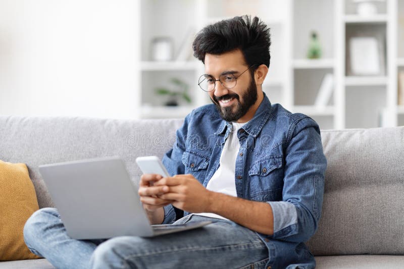 Engrossed Indian Man in Eyeglasses Multitasking with Laptop and ...