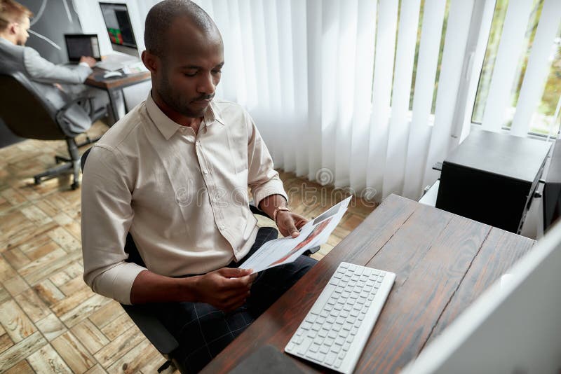 Enjoy the Difference. High-angle View of Young Trader Sitting by Desk ...